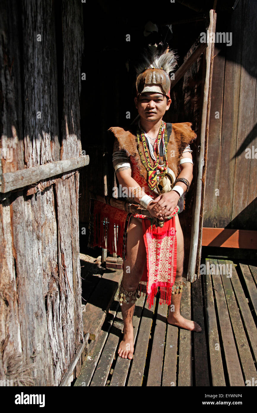 Man in traditional native Iban costume in a longhouse in Borneo ...