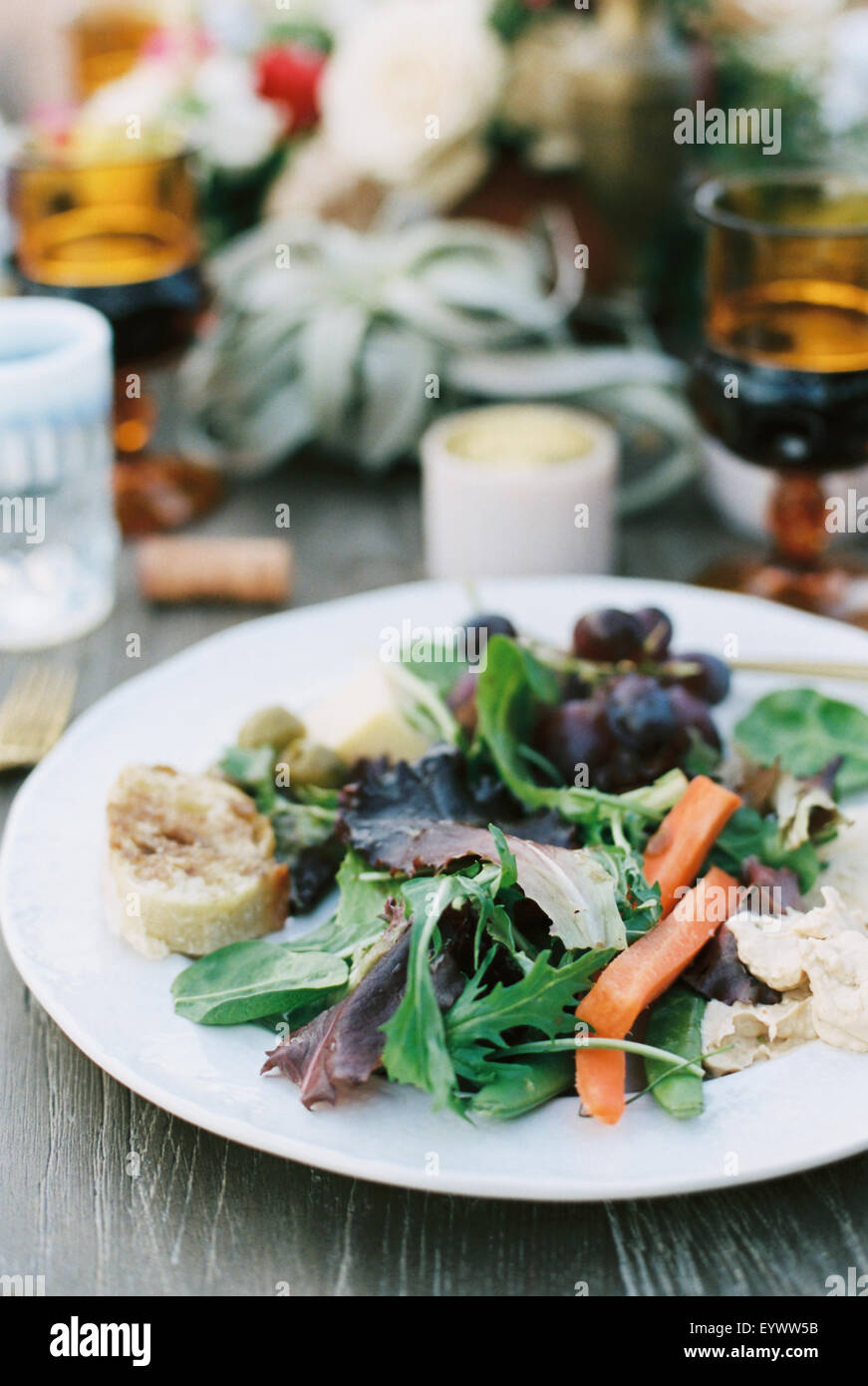 An outdoor meal in a desert, a plate with a fresh salad on a table ...