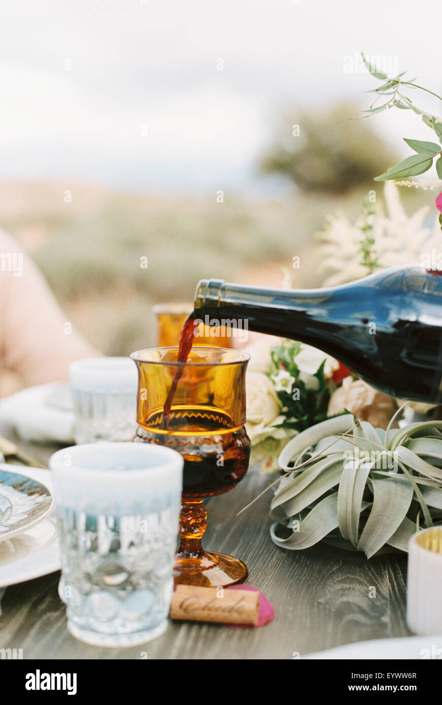 An outdoor meal in a desert, red wine being poured into a glass Stock ...