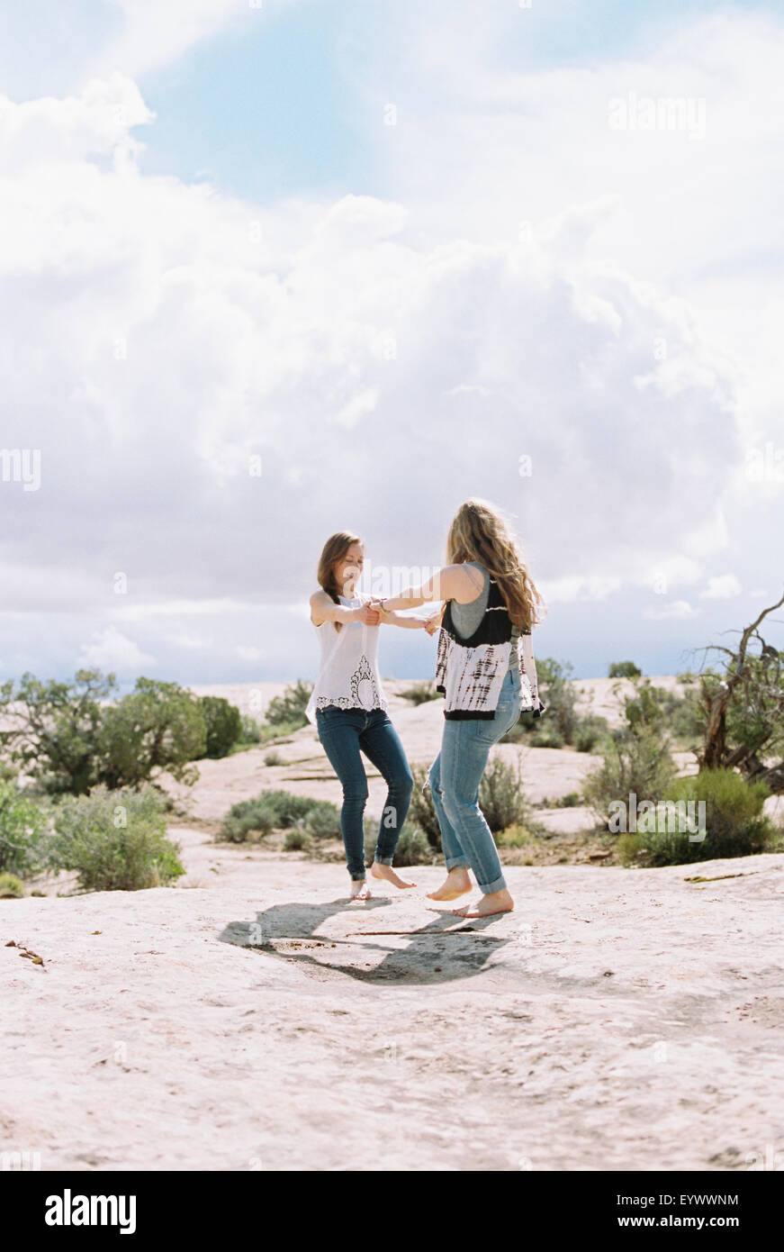 Two barefoot woman holding hands, dancing Stock Photo - Alamy