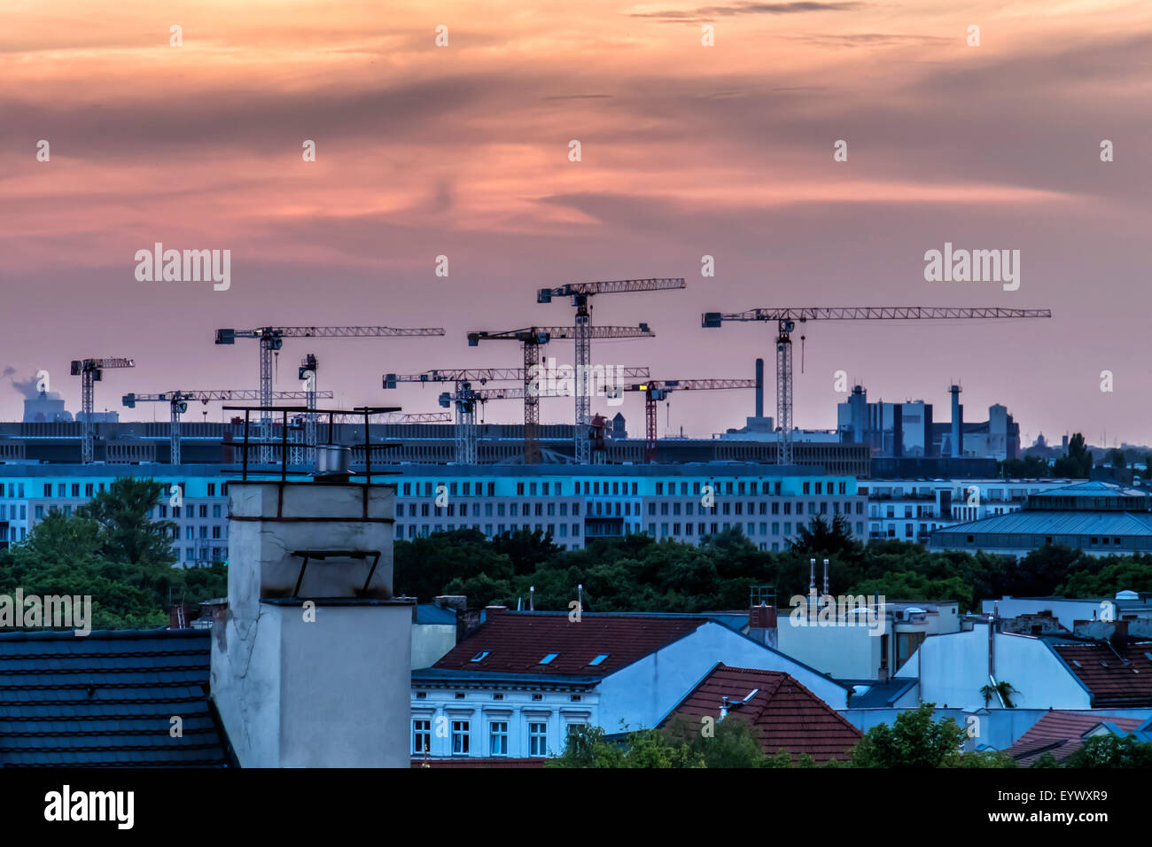 Berlin sunset view from apartment building rooftop. Cranes, buildings ...