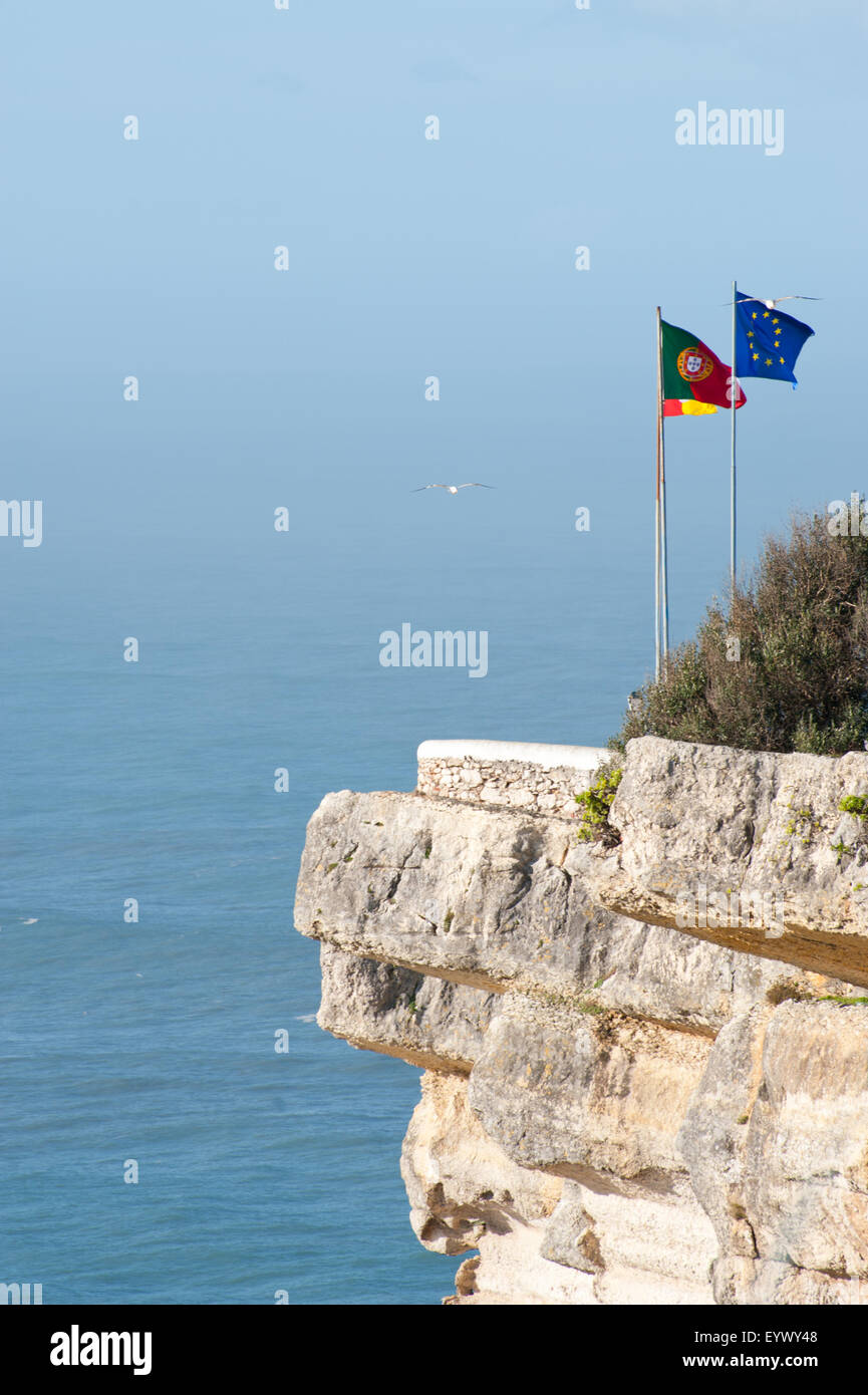 View on the cliff with European flags in Nazare Portugal Stock Photo ...