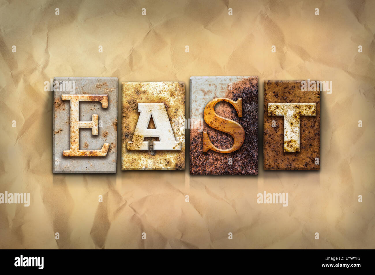 The word "EAST" written in rusty metal letterpress type on a crumbled ...