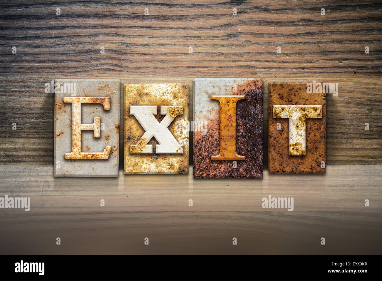 The word "EXIT" written in rusty metal letterpress type sitting on a ...