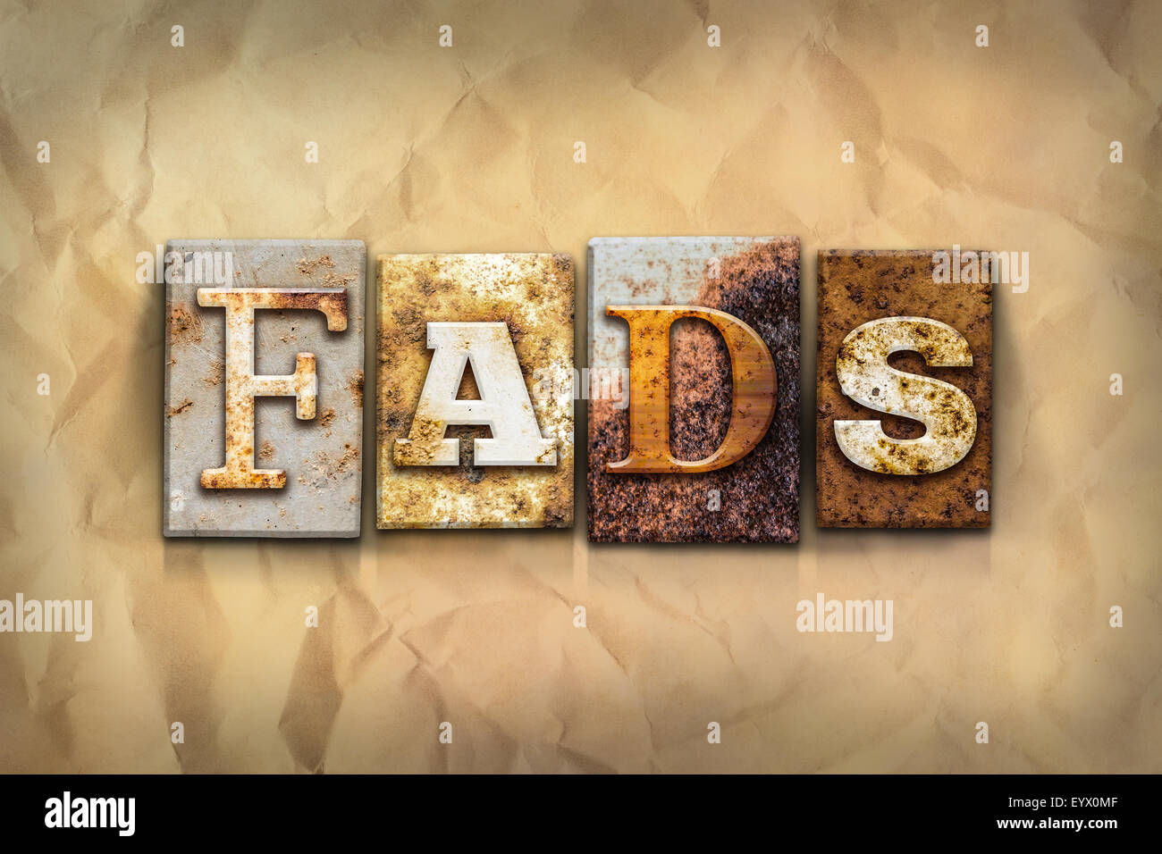 The word "FADS" written in rusty metal letterpress type on a crumbled ...