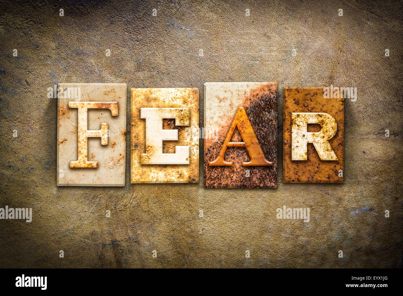 The word "FEAR" written in rusty metal letterpress type on an old aged ...