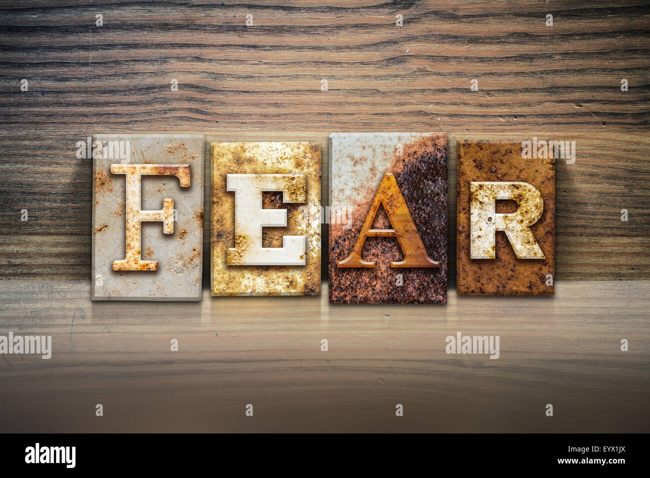 The word "FEAR" written in rusty metal letterpress type sitting on a ...