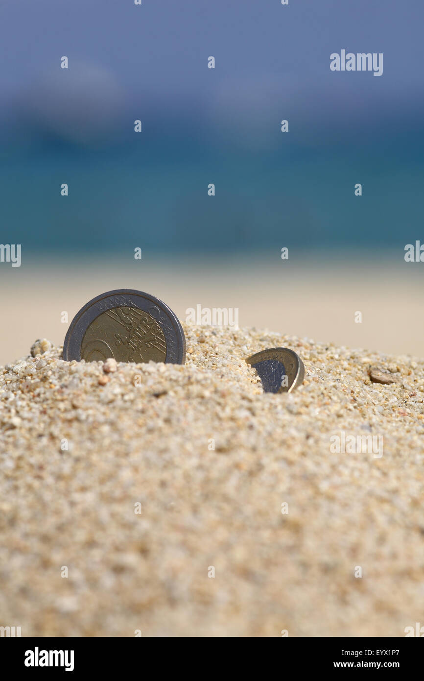 euro coins buried on beach Stock Photo - Alamy