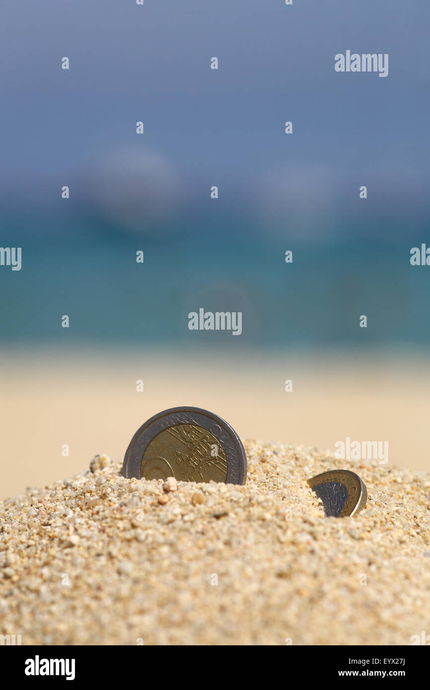 euro coins buried on beach Stock Photo - Alamy