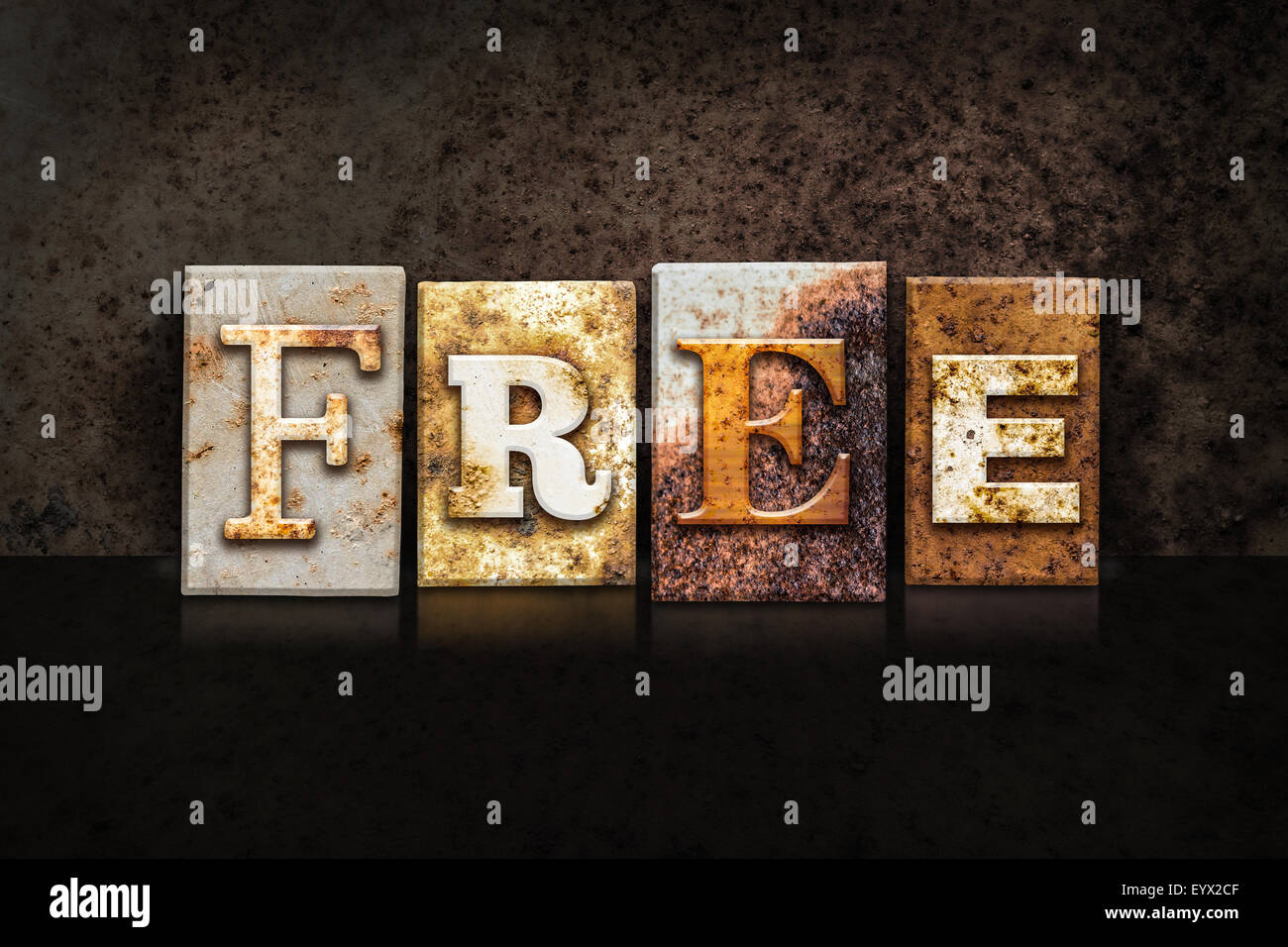The word "FREE" written in rusty metal letterpress type on a dark ...
