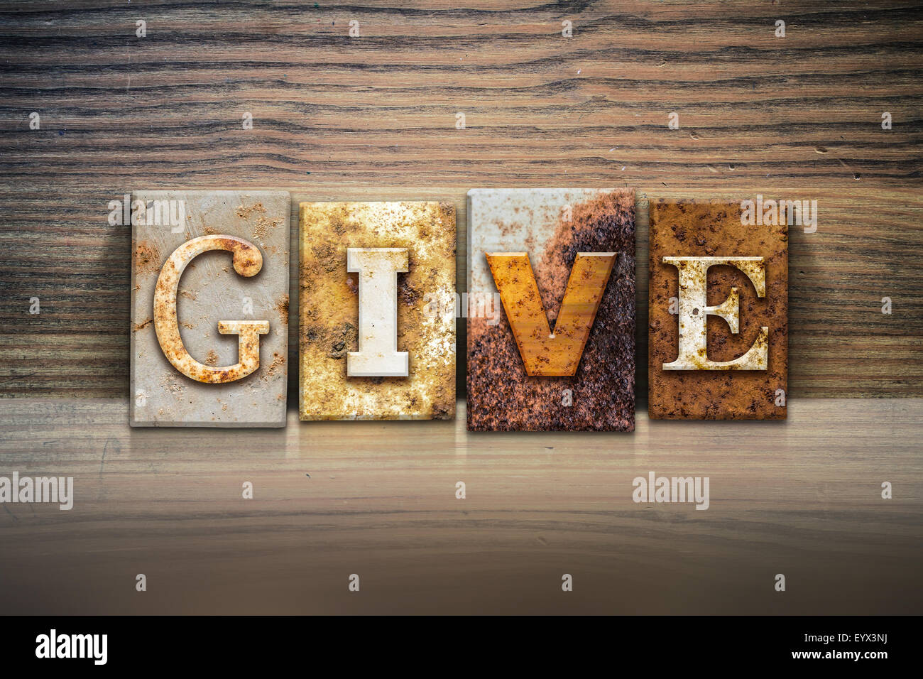 The word "GIVE" written in rusty metal letterpress type sitting on a ...