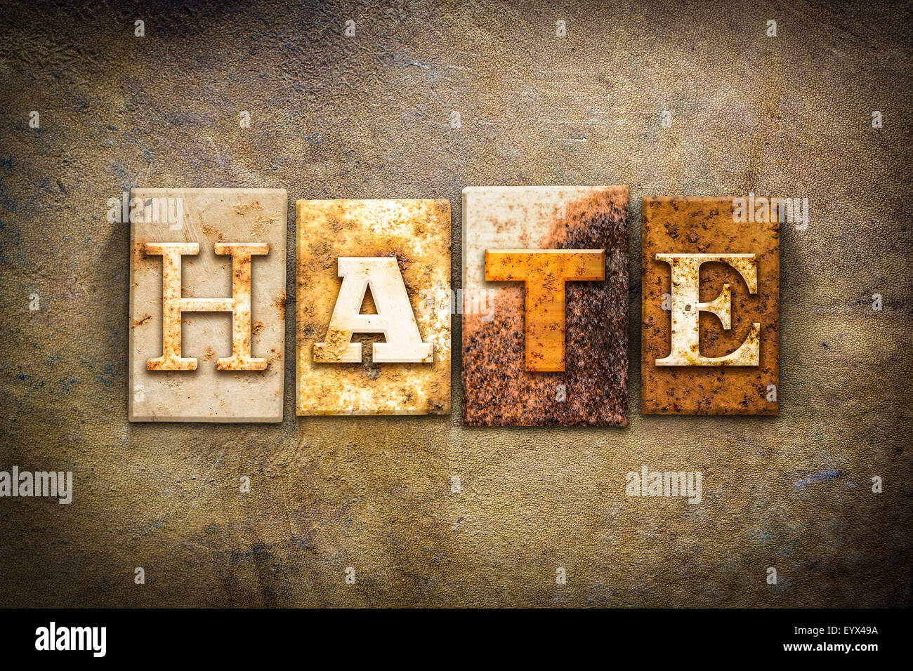 The word "HATE" written in rusty metal letterpress type on an old aged ...