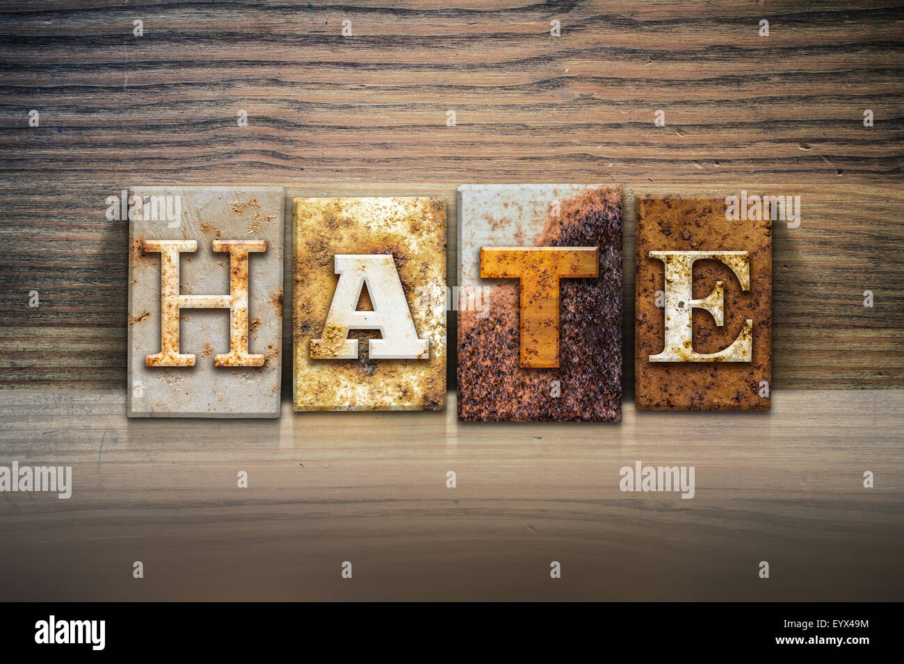 The word "HATE" written in rusty metal letterpress type sitting on a ...
