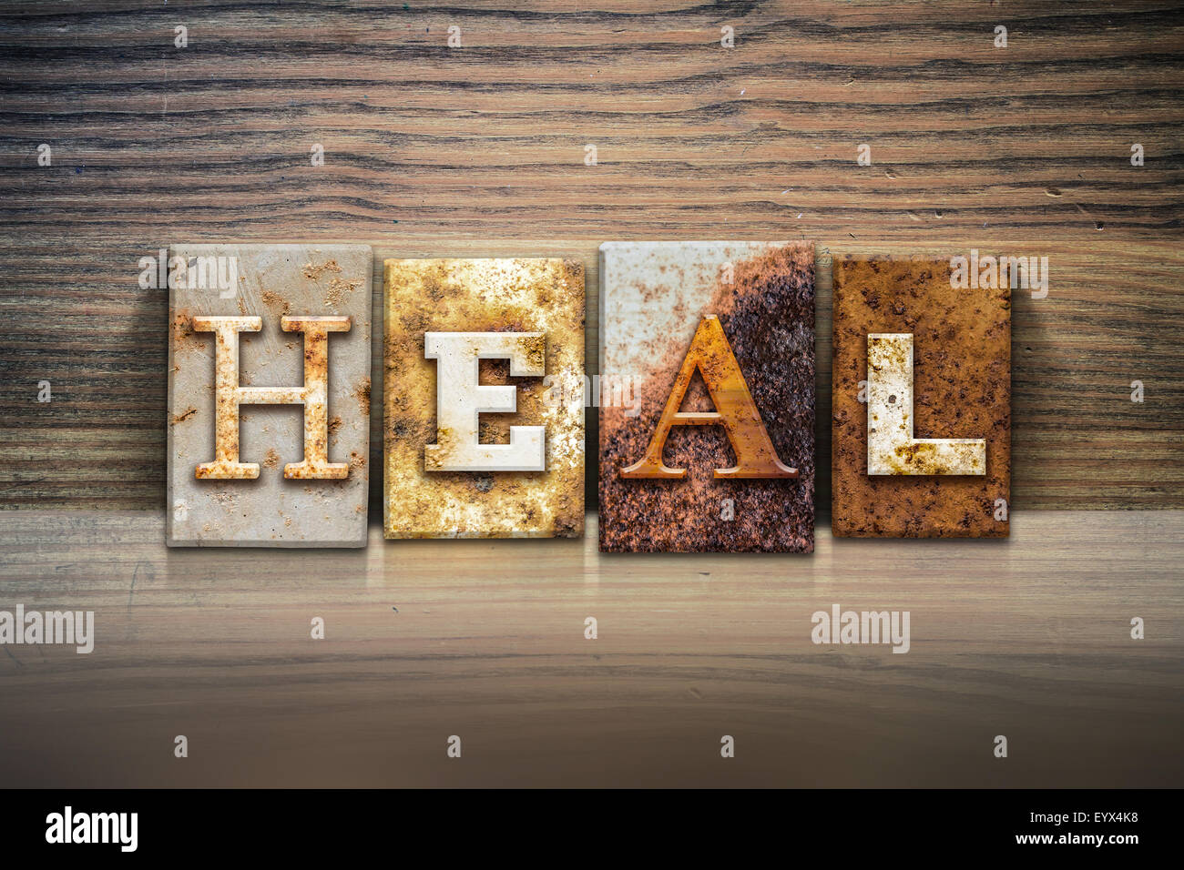 The word "HEAL" written in rusty metal letterpress type sitting on a ...