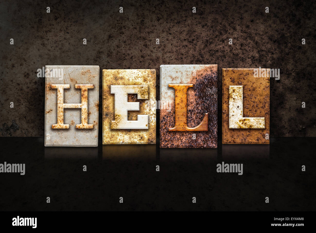 The word "HELL" written in rusty metal letterpress type on a dark ...