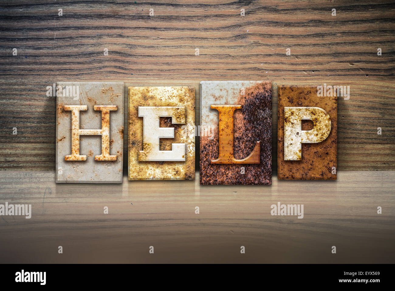 The word "HELP" written in rusty metal letterpress type sitting on a ...