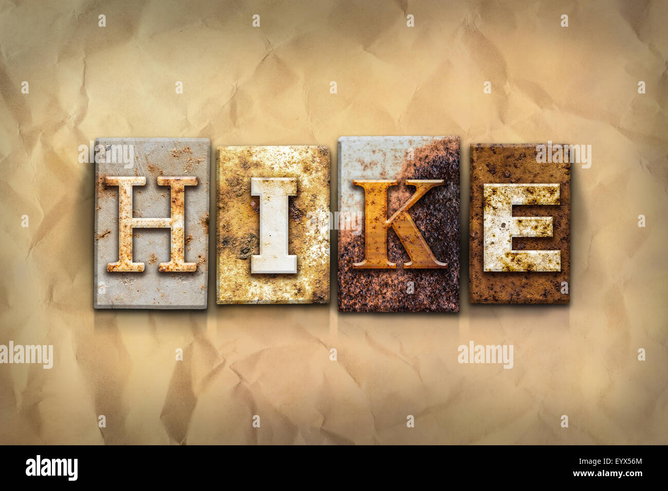 The word "HIKE" written in rusty metal letterpress type on a crumbled ...