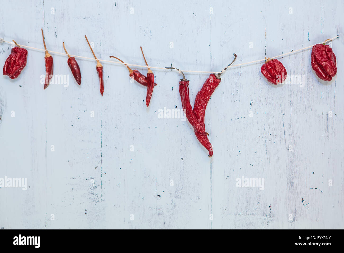 some types of hot chili peppers on rope for drying Stock Photo - Alamy