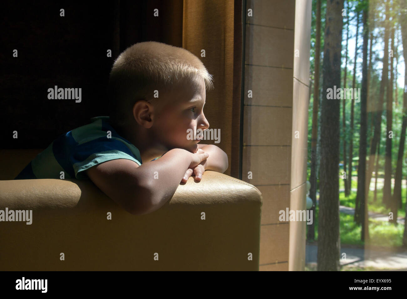Sad upset waiting boring depressed child (boy) near a window Stock ...