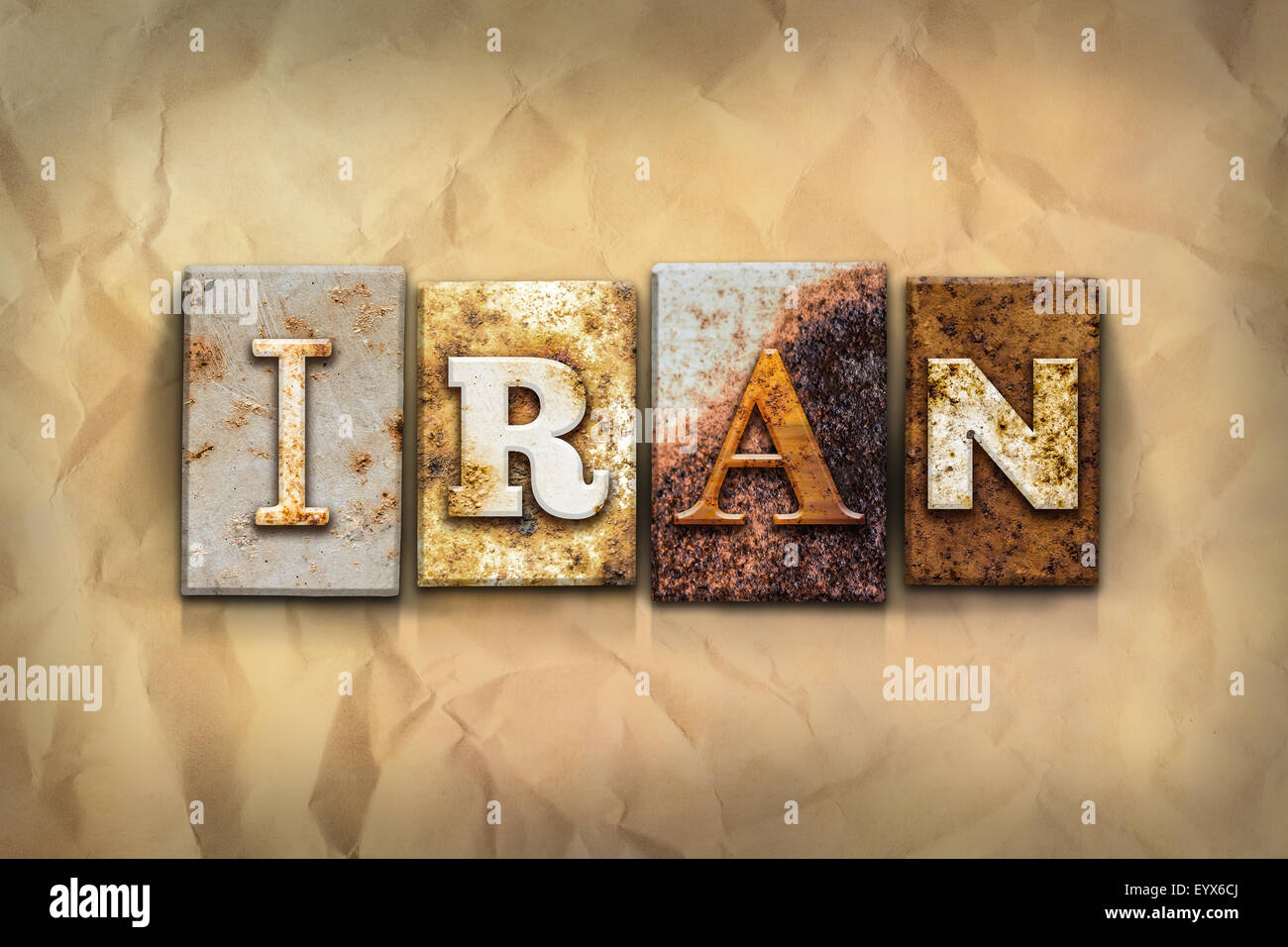 The word "IRAN" written in rusty metal letterpress type on a crumbled ...