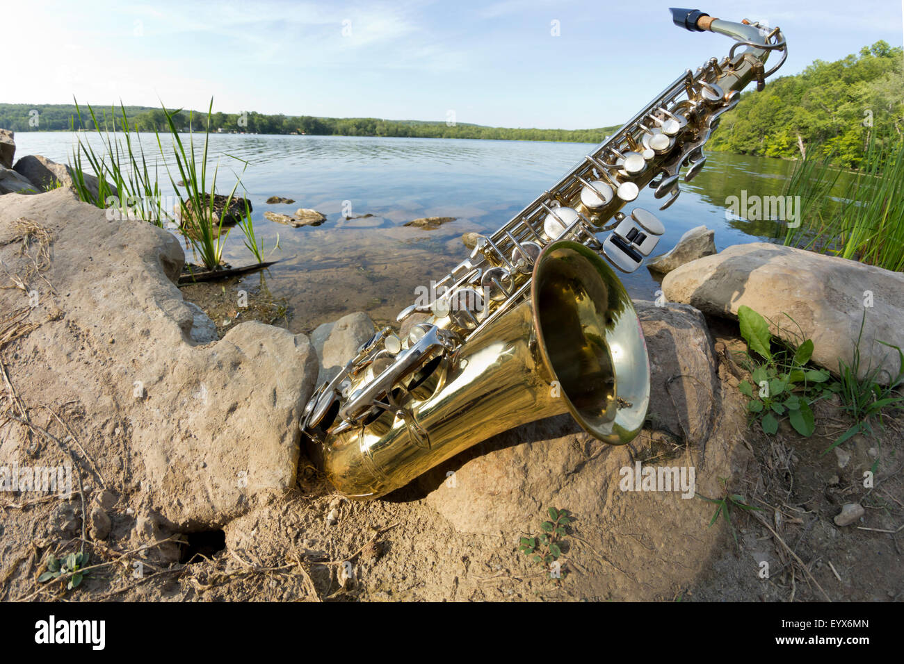 Summer Jazz saxophone in nature lying on rocks lakeside Stock Photo - Alamy
