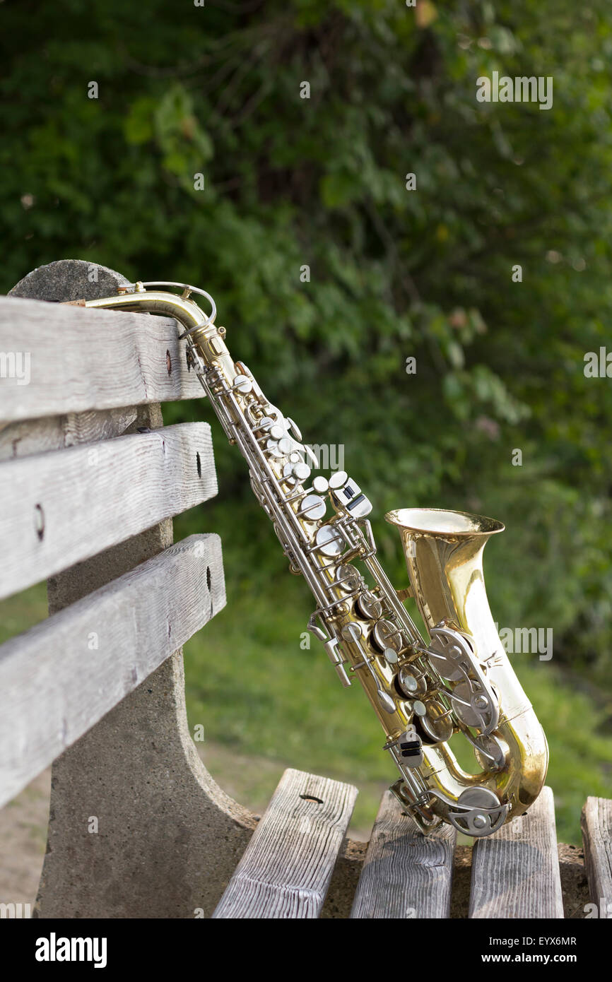 Summer Jazz saxophone in nature propped on park bench Stock Photo - Alamy