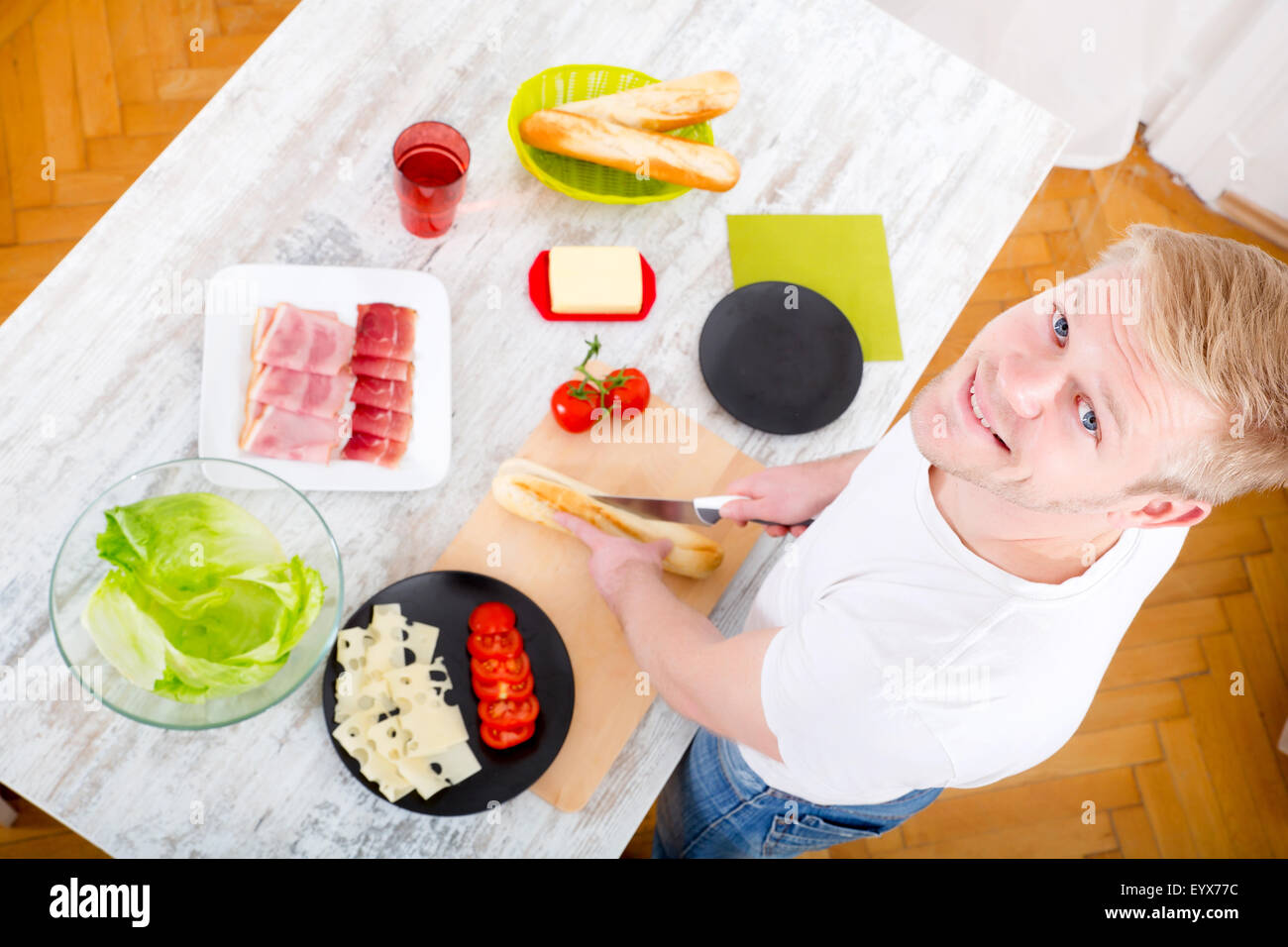 A young man preparing a sandwich in the kitchen Stock Photo - Alamy