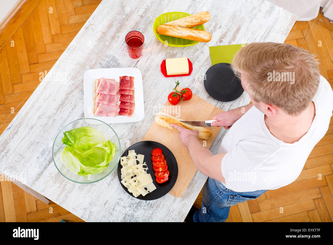 A young man preparing a sandwich in the kitchen Stock Photo - Alamy