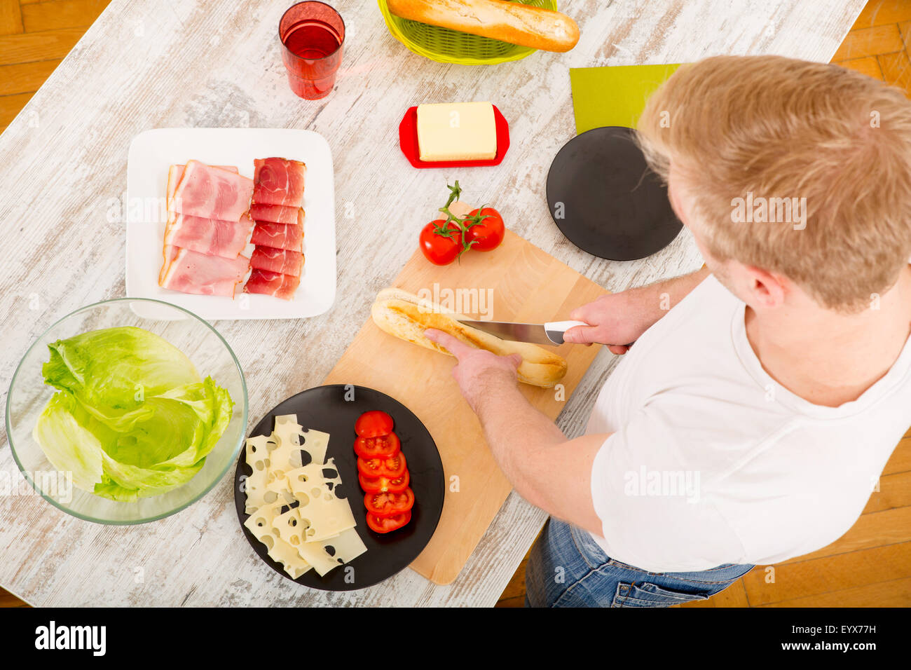 A young man preparing a sandwich in the kitchen Stock Photo - Alamy