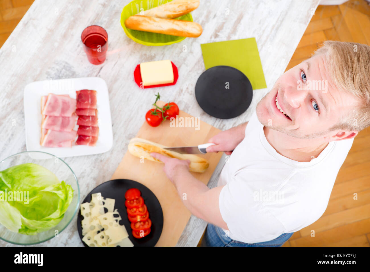 A young man preparing a sandwich in the kitchen Stock Photo - Alamy