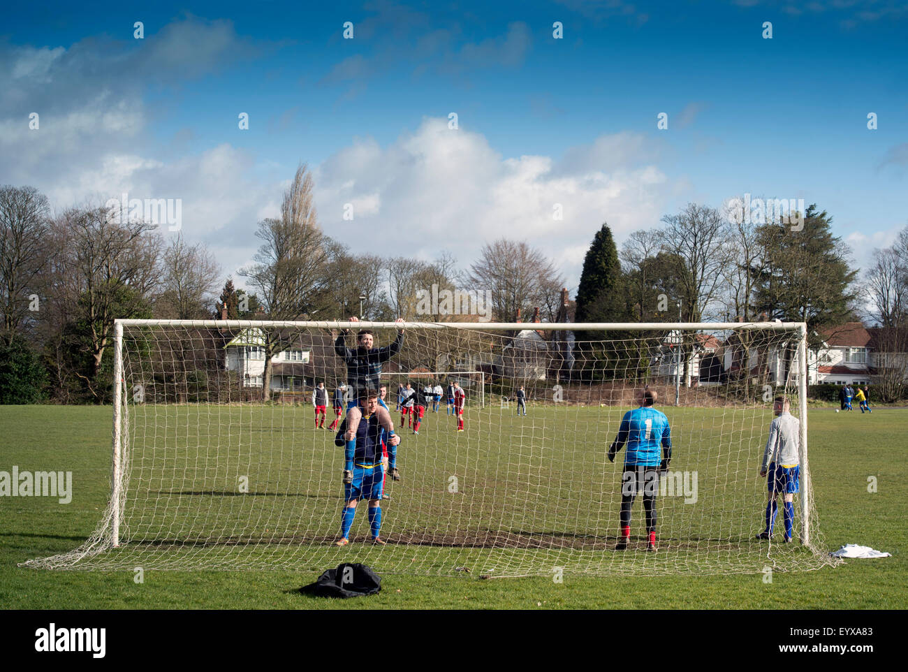 Sunday League amateur footballers putting up the nets at a match in ...