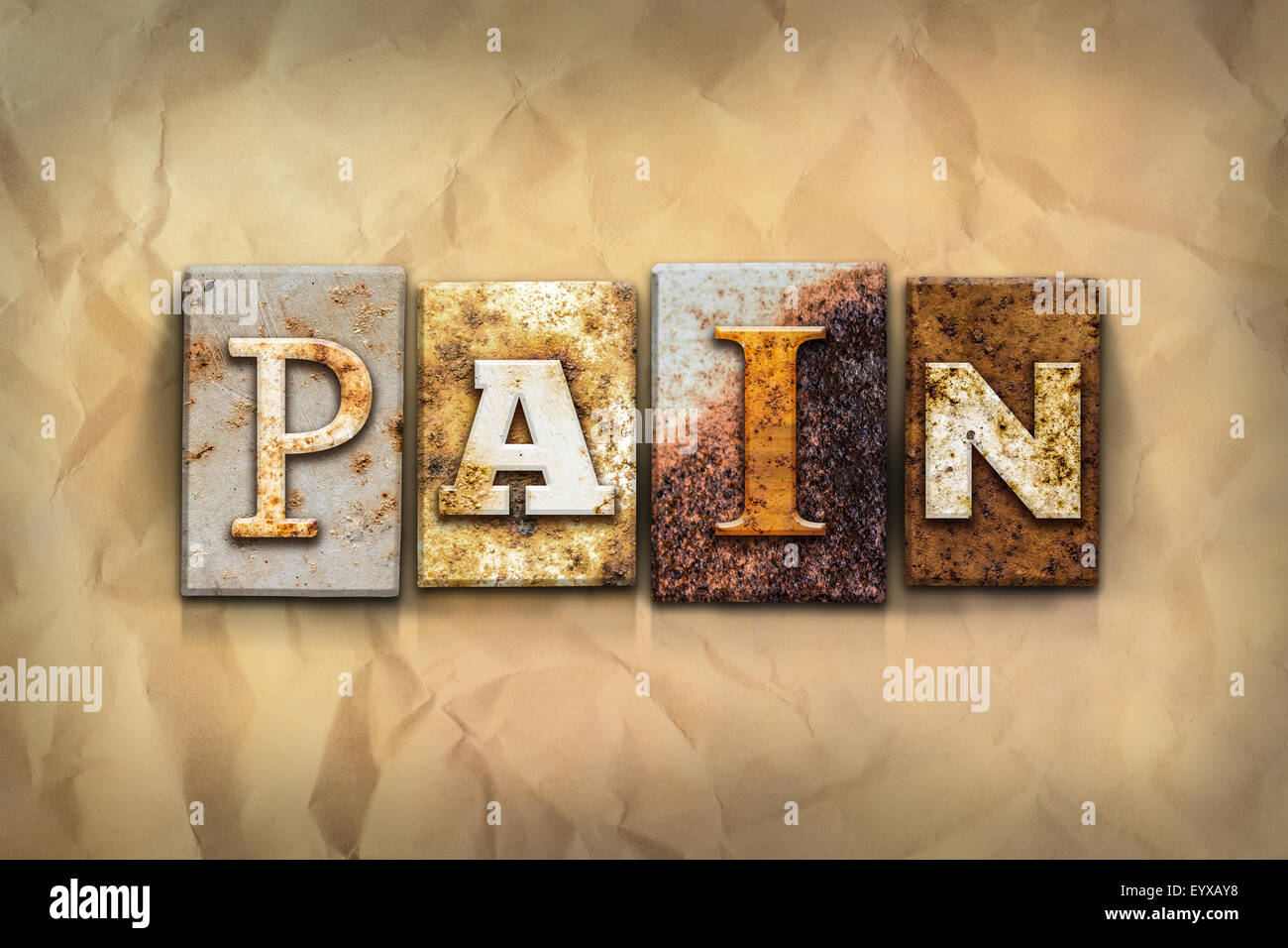 The word "PAIN " written in rusty metal letterpress type on a crumbled ...
