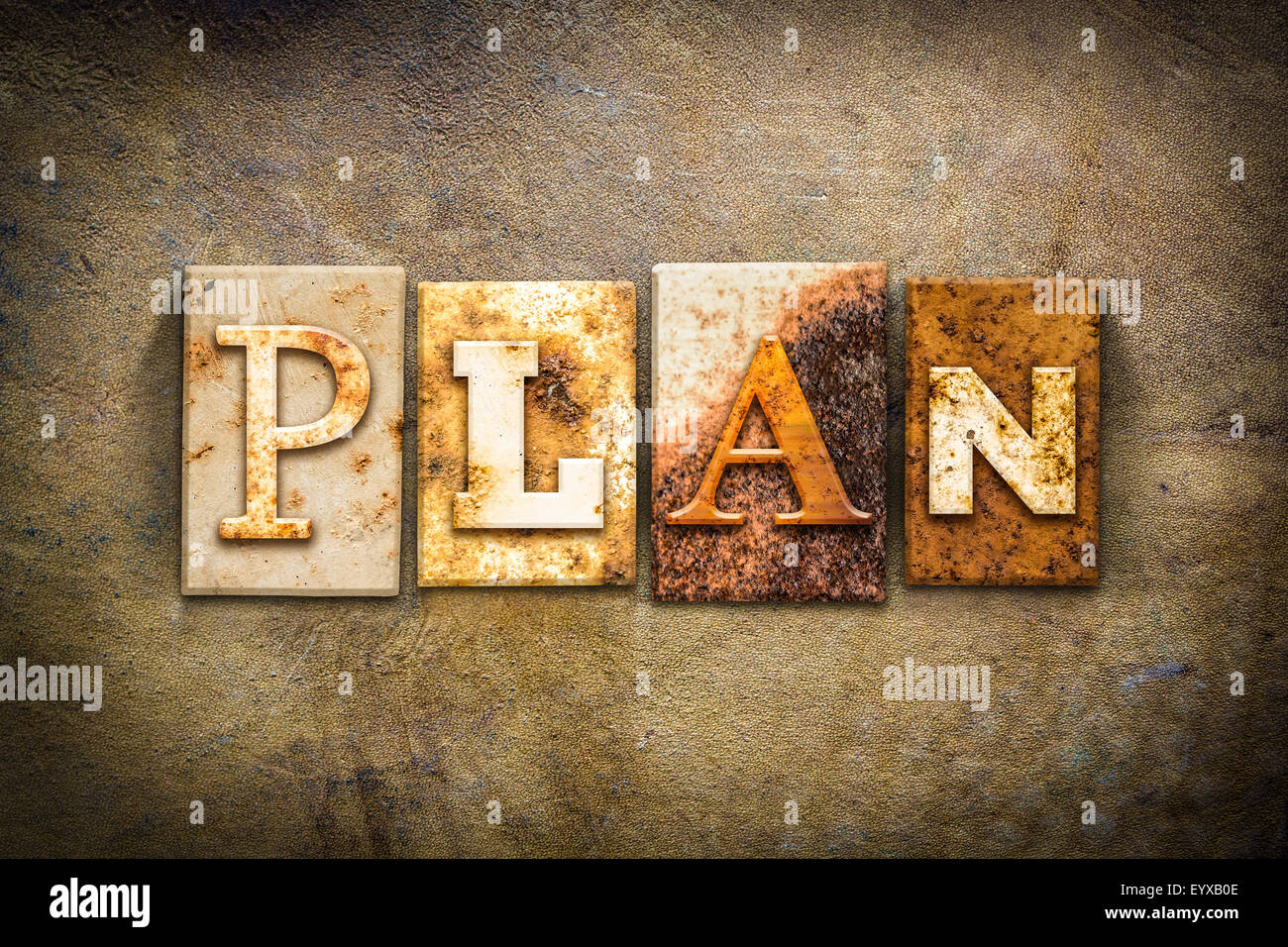 The word "PLAN" written in rusty metal letterpress type on an old aged ...
