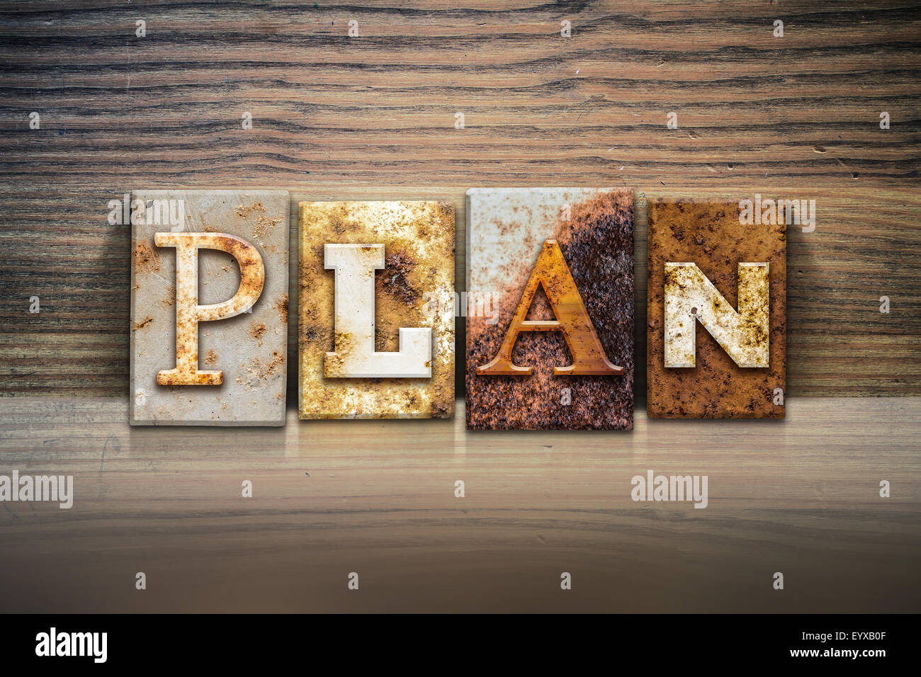 The word "PLAN" written in rusty metal letterpress type sitting on a ...