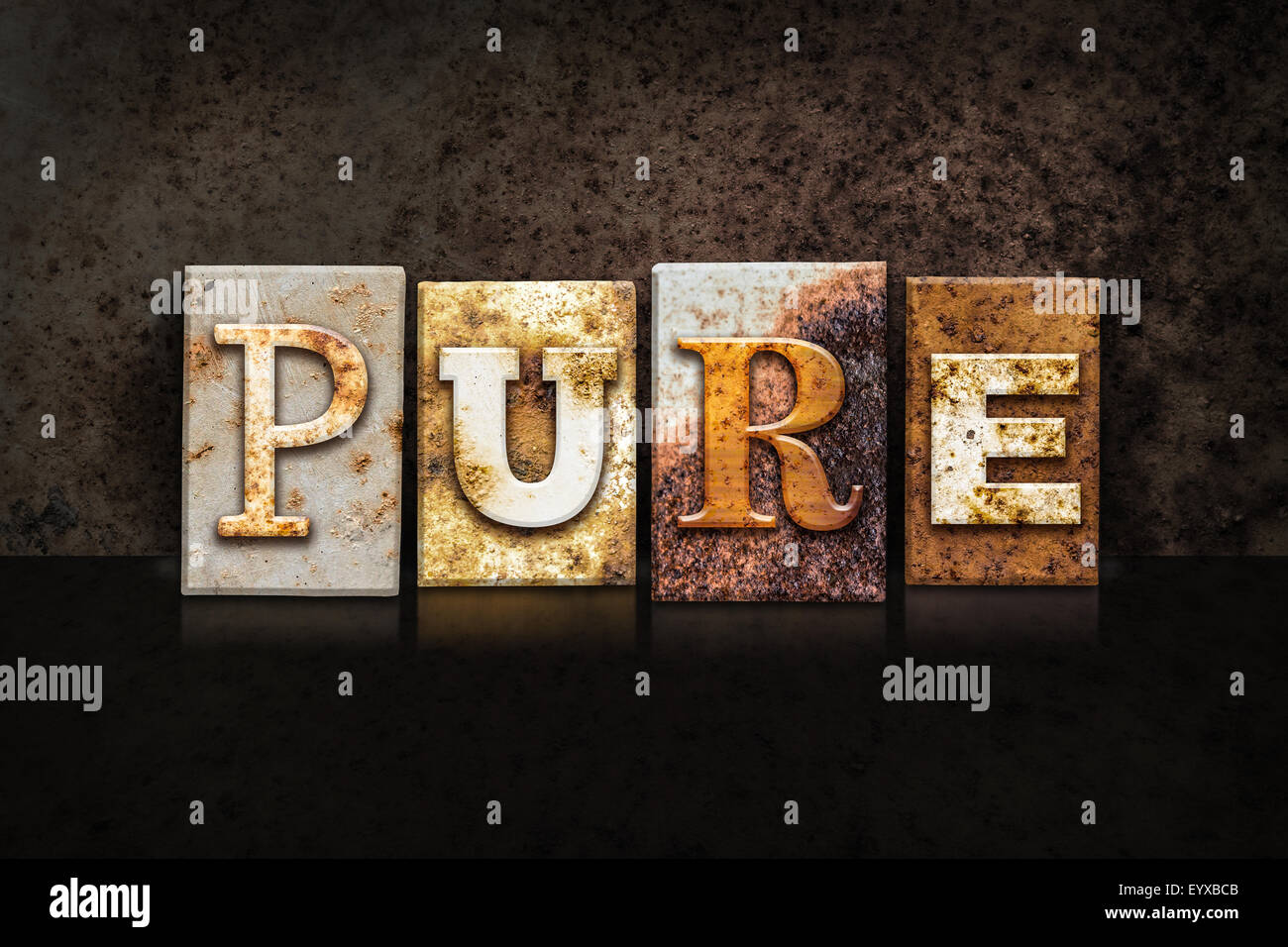 The word "PURE" written in rusty metal letterpress type on a dark ...
