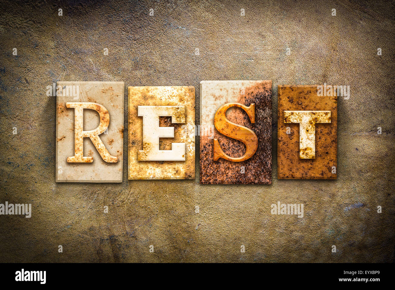 The word "REST" written in rusty metal letterpress type on an old aged ...