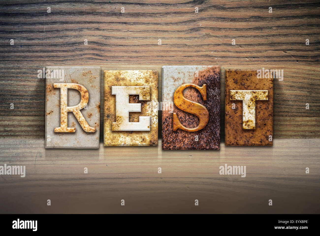 The word "REST" written in rusty metal letterpress type sitting on a ...