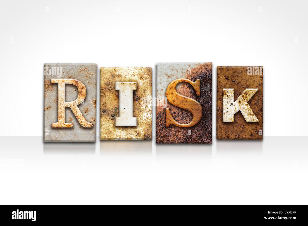 The word "RISK" written in rusty metal letterpress type isolated on a ...
