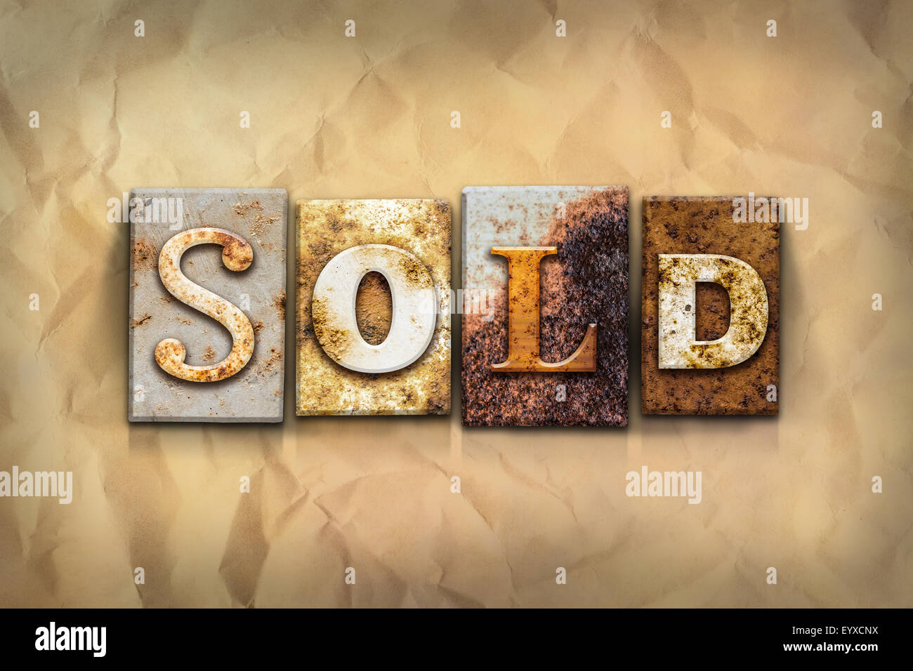 The word "SOLD" written in rusty metal letterpress type on a crumbled ...