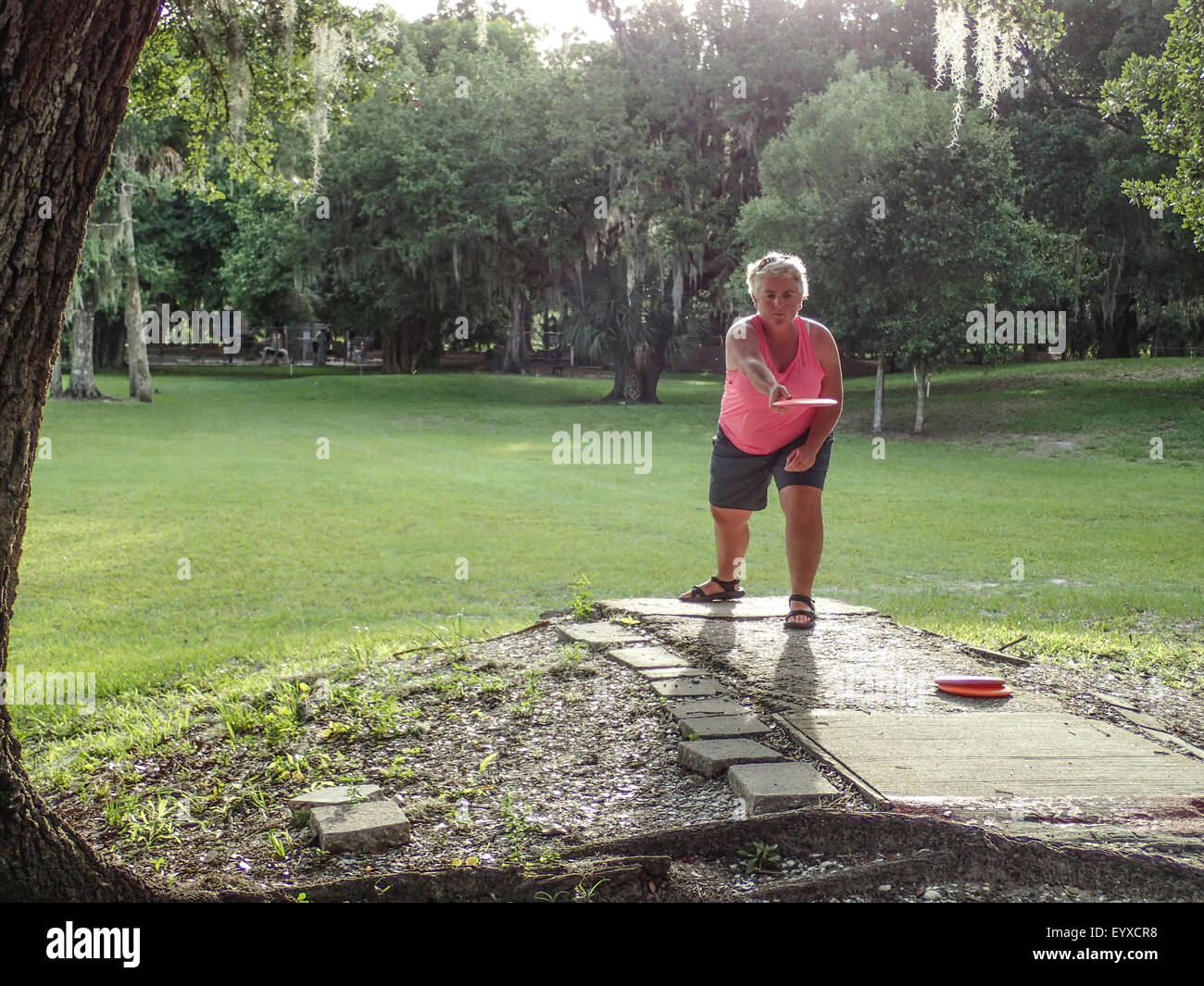 Woman playing disc golf Stock Photo - Alamy
