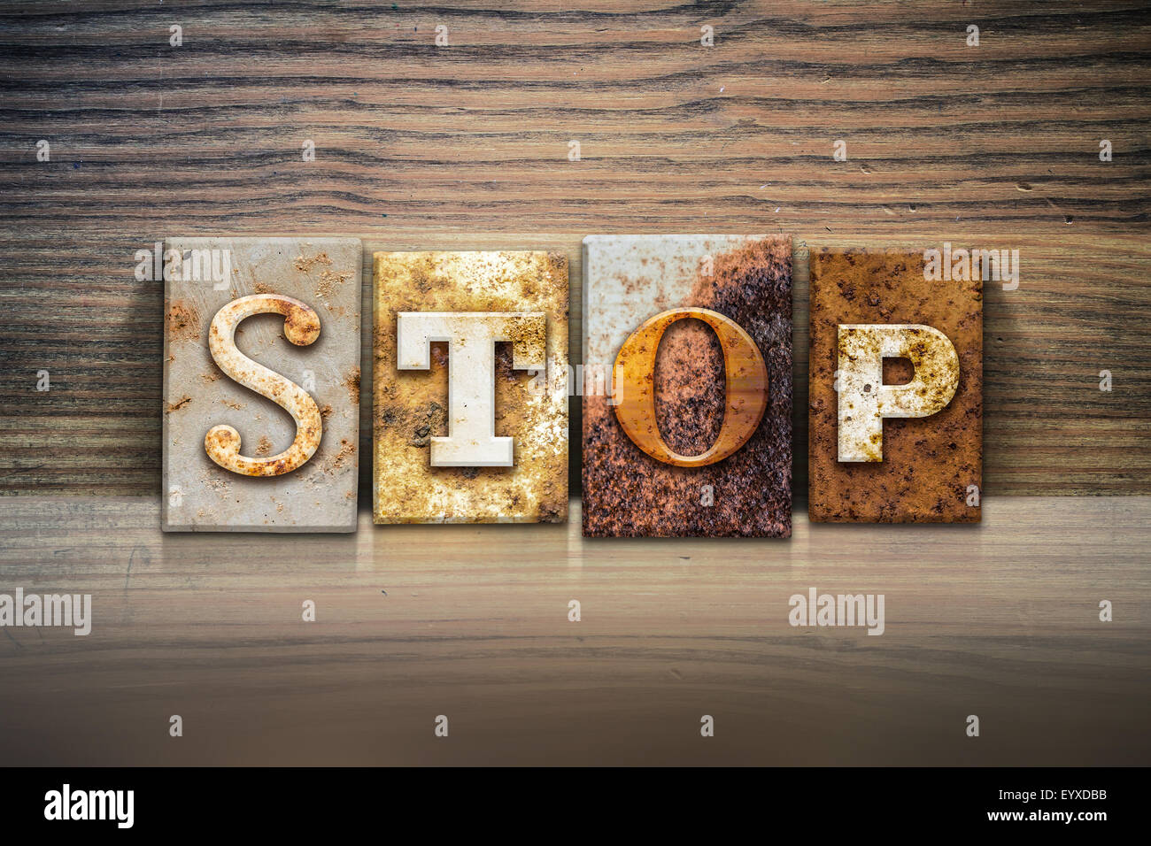 The word "STOP" written in rusty metal letterpress type sitting on a ...