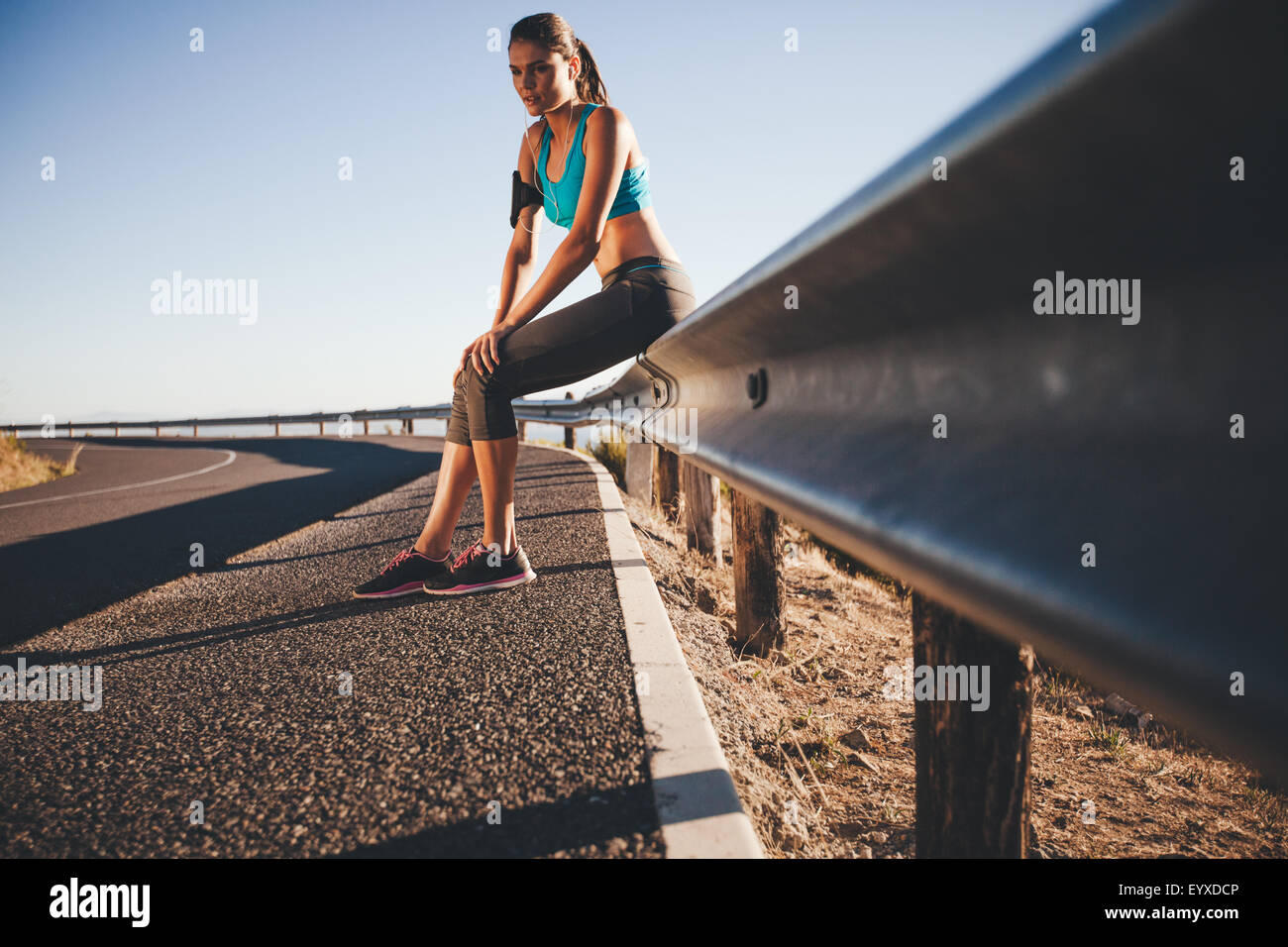 Outdoor shot of young female runner taking a break. Tired young woman ...