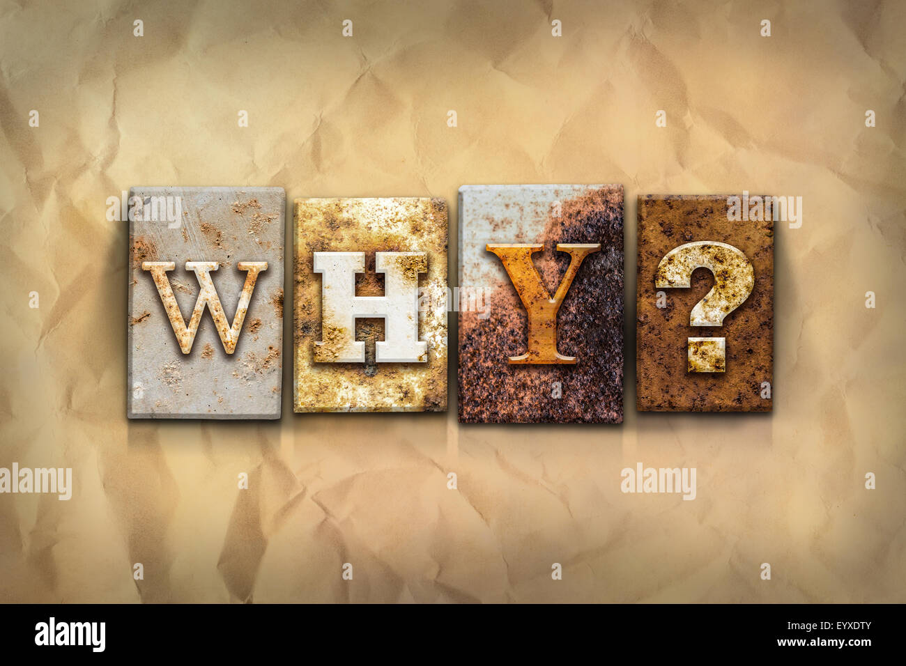 The word "WHY?" written in rusty metal letterpress type on a crumbled ...