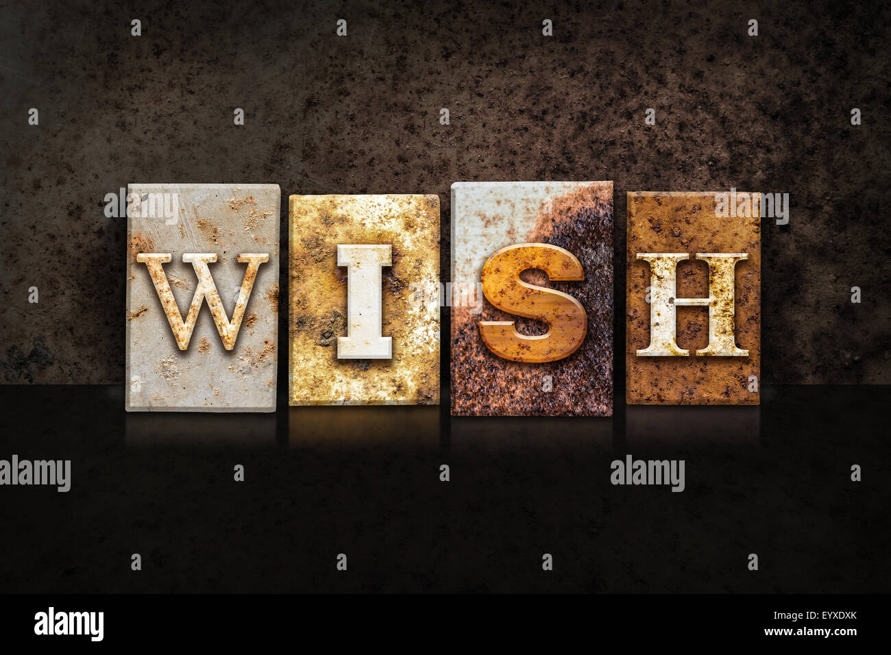 The word "WISH" written in rusty metal letterpress type on a dark ...