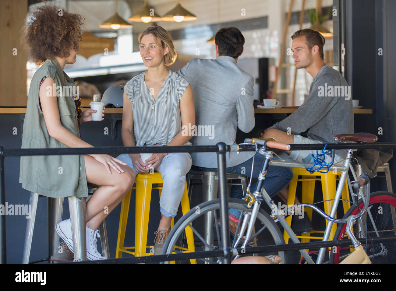 Friends hanging out talking and drinking coffee on cafe patio Stock ...
