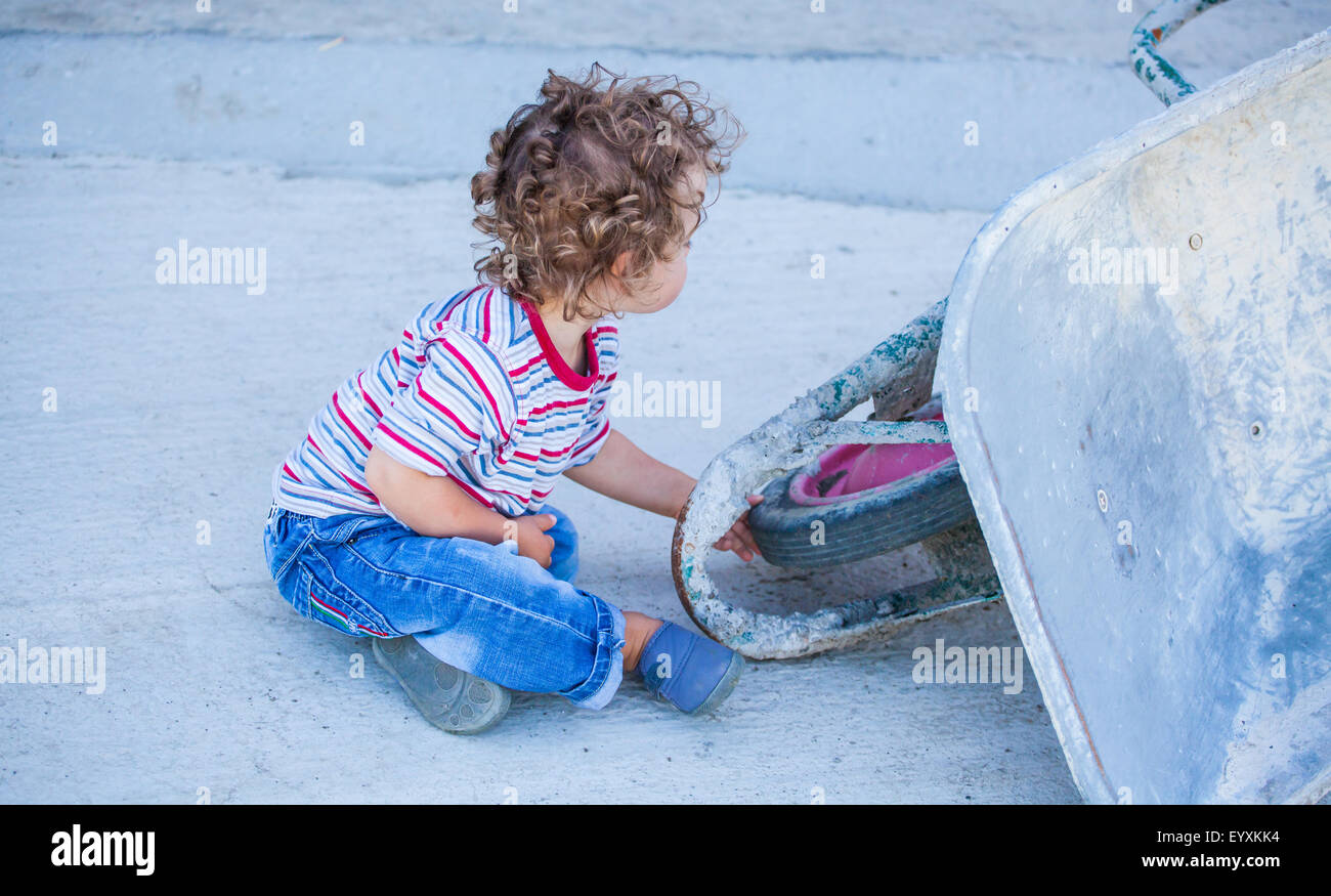 Portrait of 1 year old baby boy playing with a wheel barrow Stock Photo ...