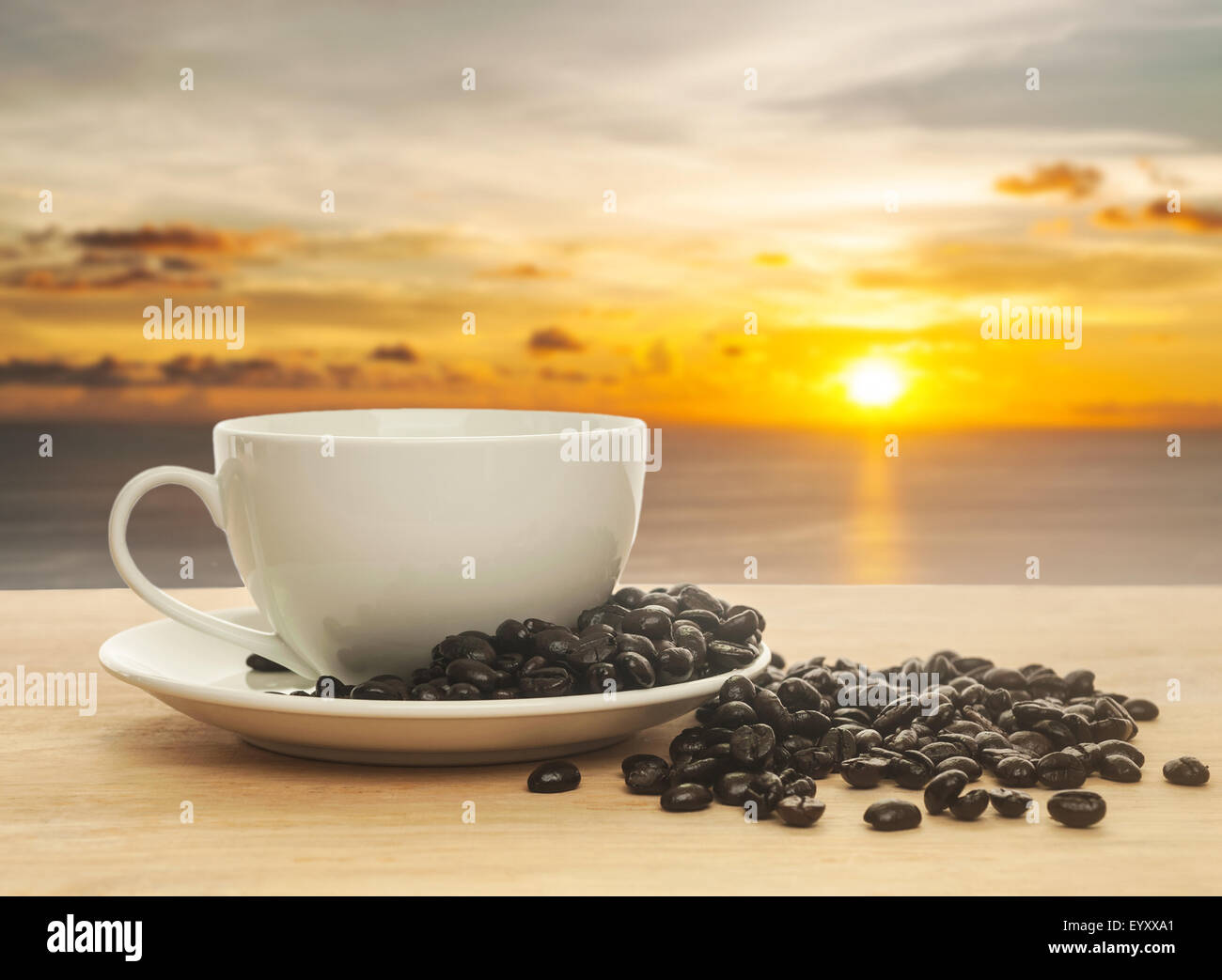 Fresh coffee in a white cup of coffee on wooden with sunrise background ...