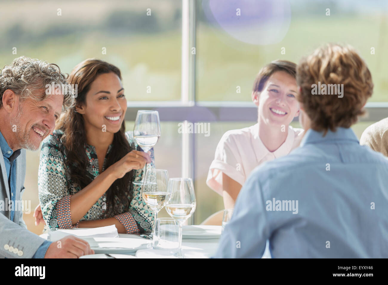 Friends drinking wine and talking at restaurant table Stock Photo - Alamy