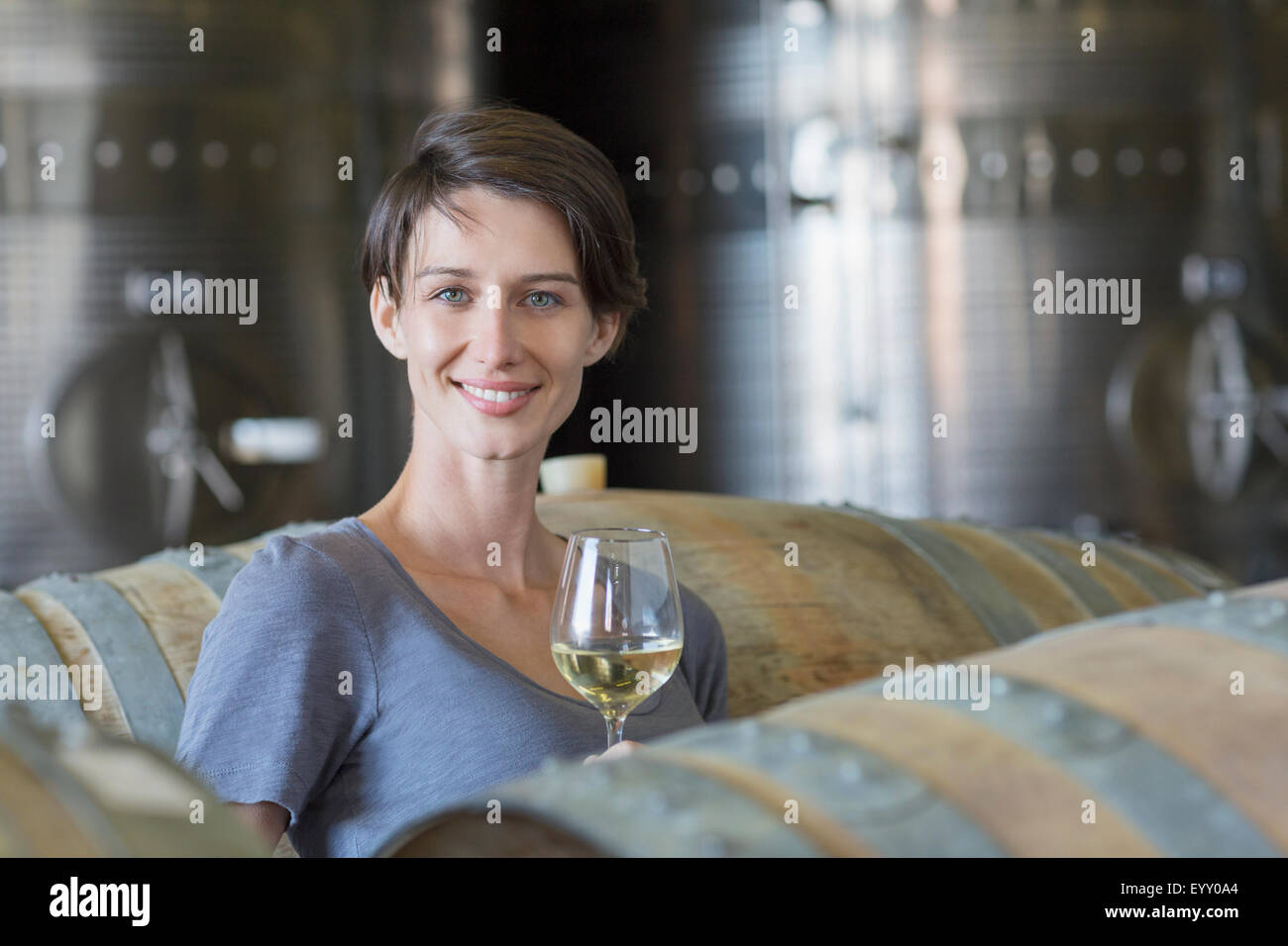 Portrait confident vintner drinking white wine in winery cellar Stock ...