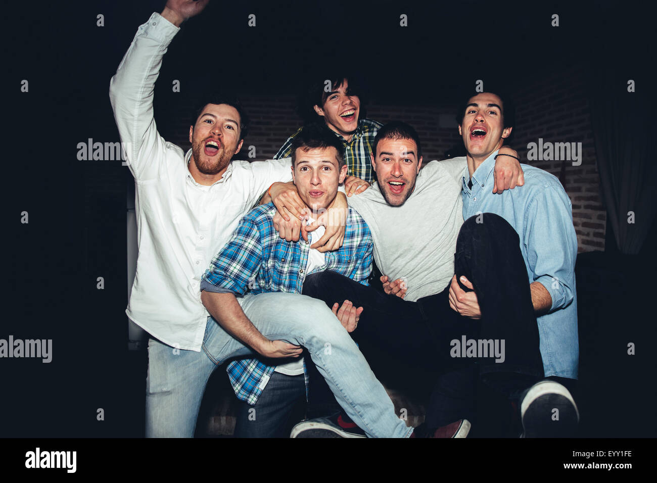 Laughing men playing at party at night Stock Photo - Alamy